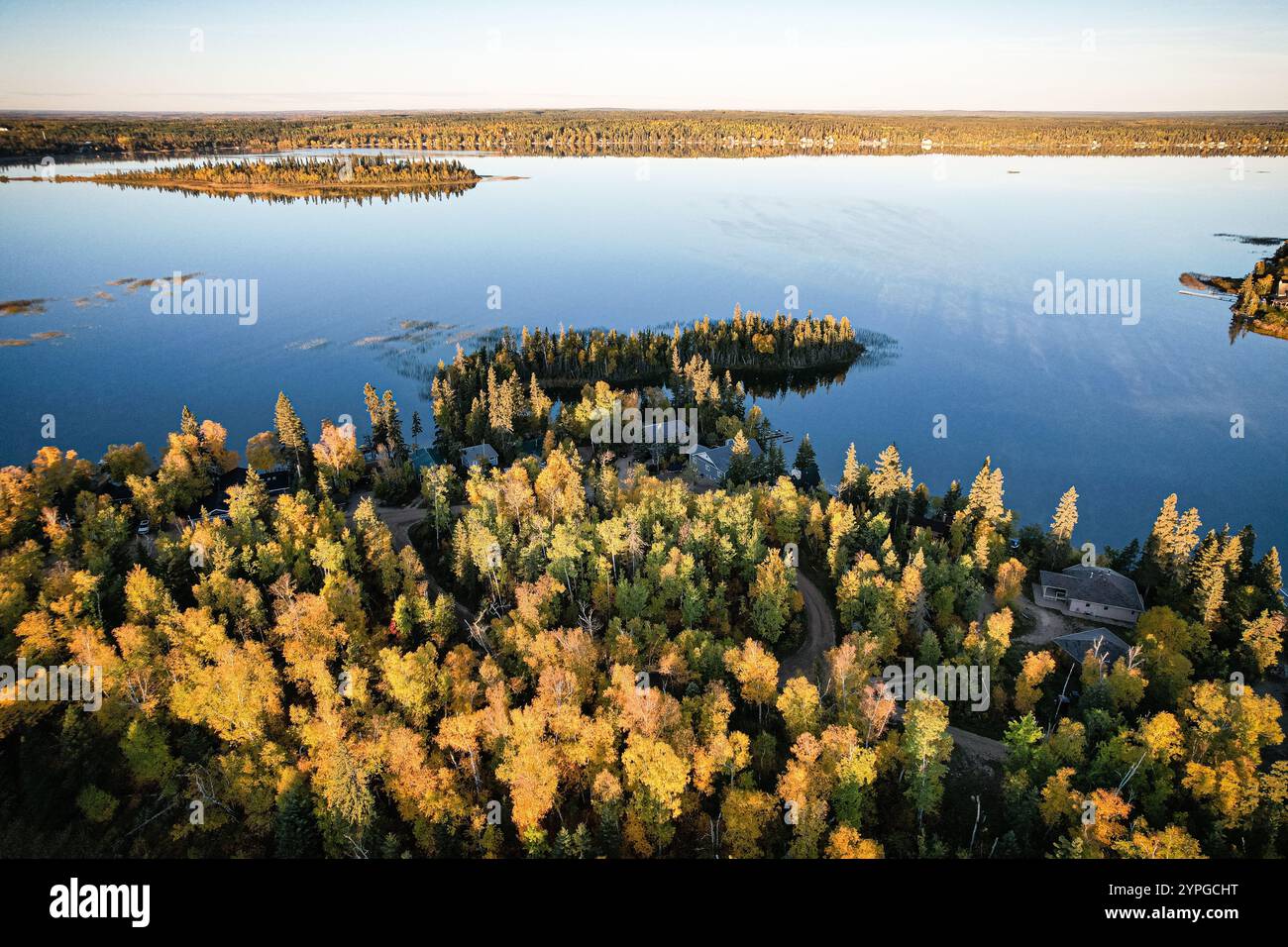 A beautiful view of a lake with trees surrounding it. The trees are in ...