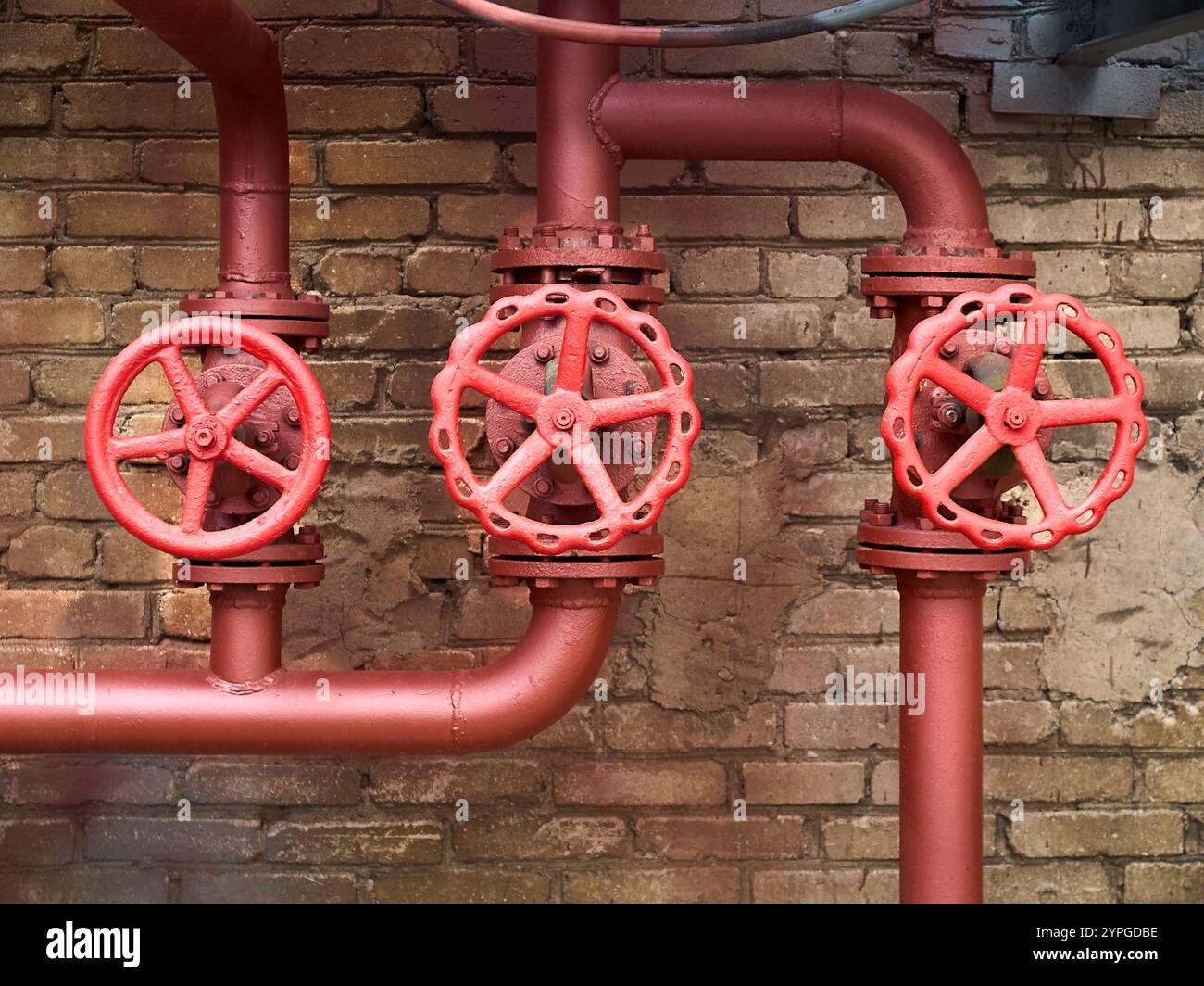 Red valves retro design on red hydrant pipelines with flanges of ...