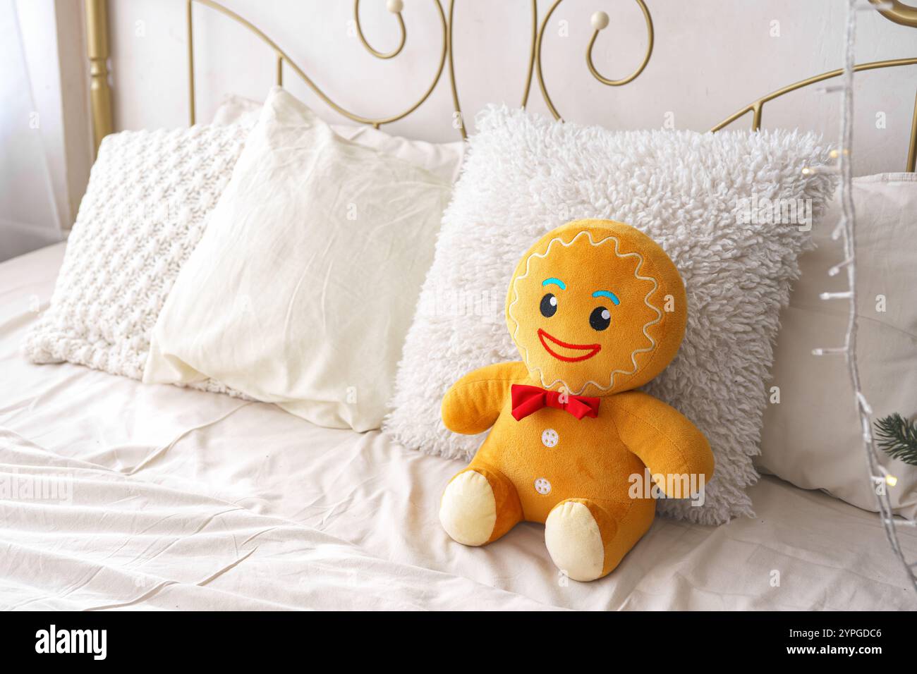 Christmas gingerbread plush toy seated on bed surrounded by fluffy ...