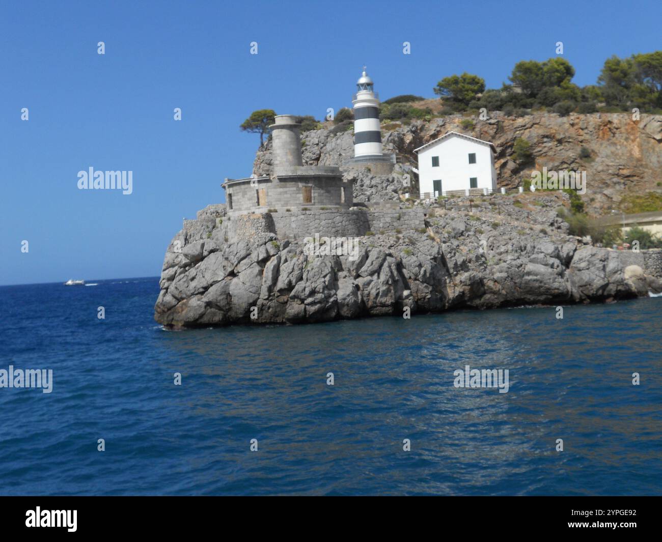 A historic lighthouse stands atop rugged cliffs by the sea. The ...