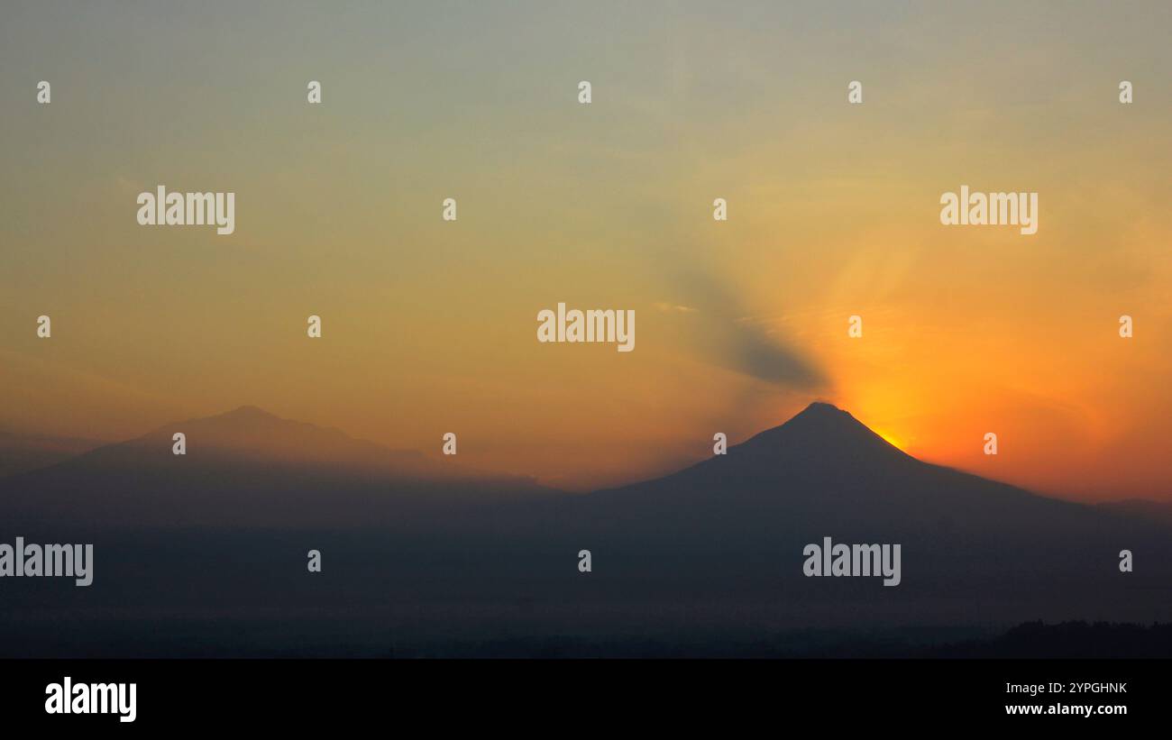 Silhouette of Mount Merapi with a red-orange sky at sunrise. The ...