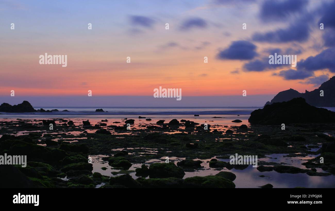 Dusk on shoreline, with the evening blue sky and dense shadows in the ...