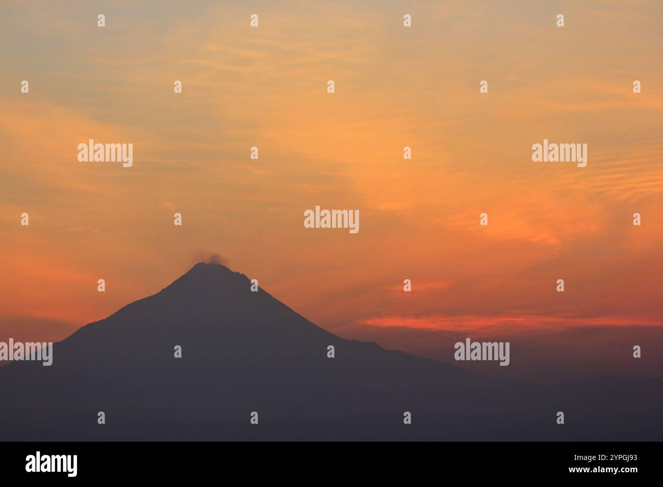 Silhouette of Mount Merapi with a red-orange sky at sunrise. The ...