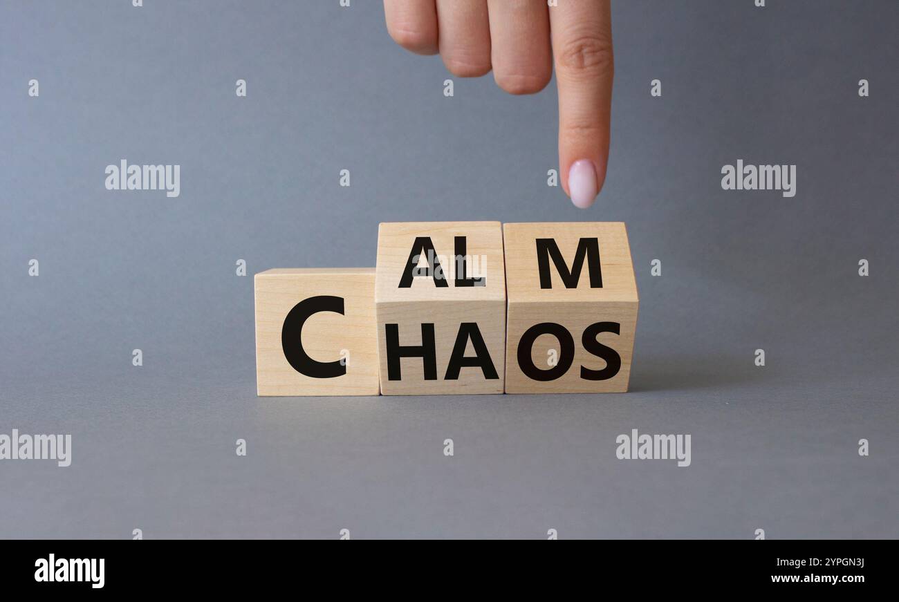 Calm vs chaos symbol. Businessman hand points at turned wooden cubes ...
