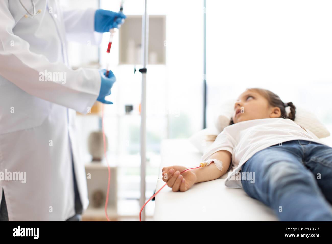 Young girl receiving blood transfusion from medical professional. Image ...