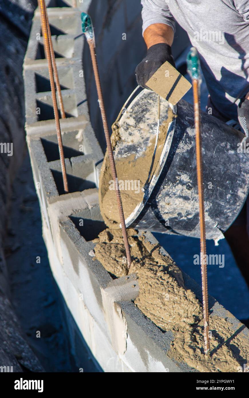 Male craftsman pouring concrete into concrete bricks. Selective focus ...