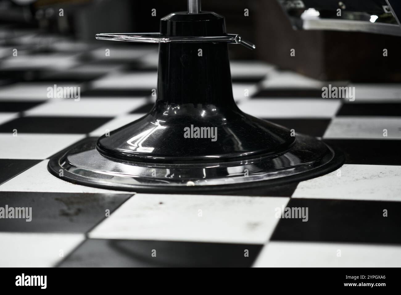 Black and white checkerboard floor with a chair base in a diner setting ...