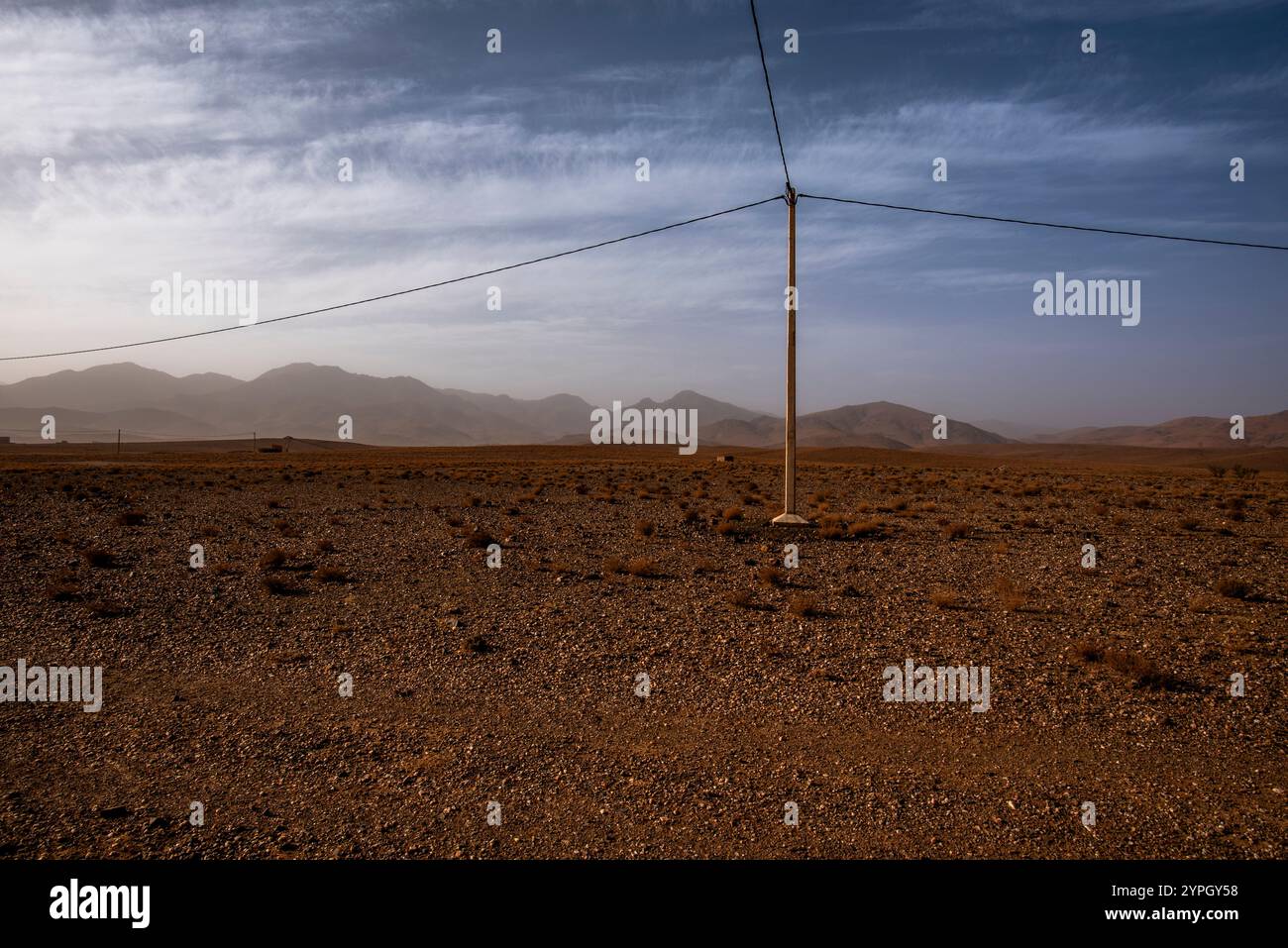 lone electricity pylon with cables forming diverging lines on blue sky ...