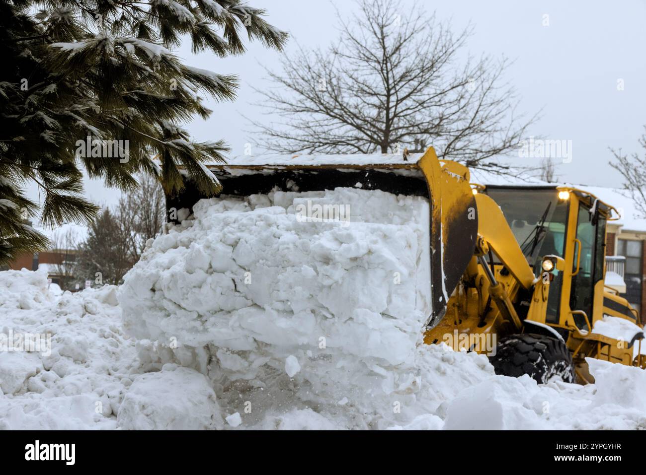 Snow is being cleared from parking lot residential street by yellow ...