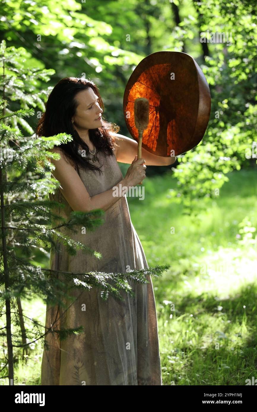 Female shaman doing authentic ritual of summoning spirits with a ...