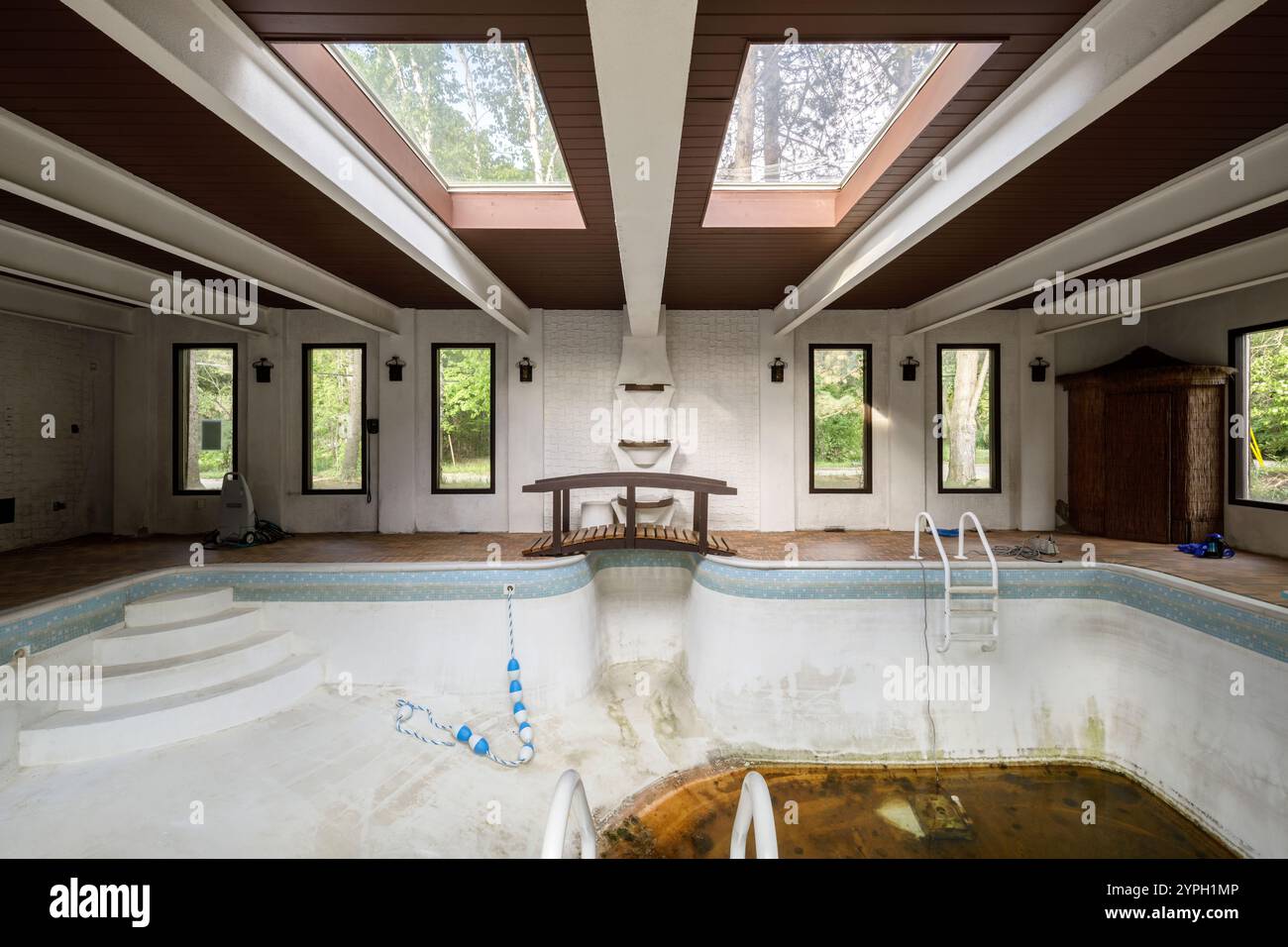 An empty indoor swimming pool with skylights inside a mansion. This ...
