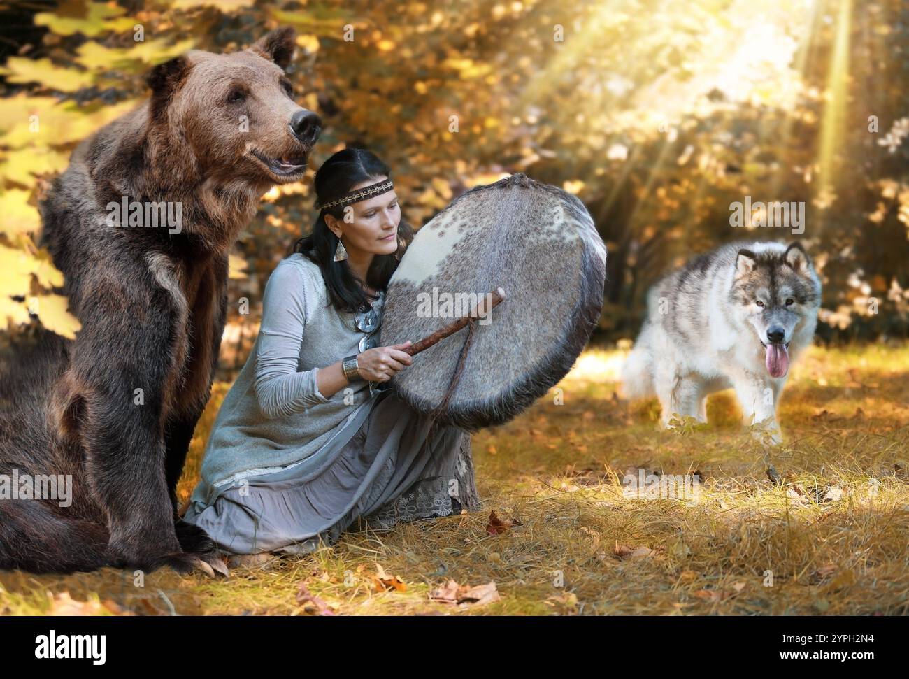 Shaman woman playing her shaman sacred drum in the forest among wild ...