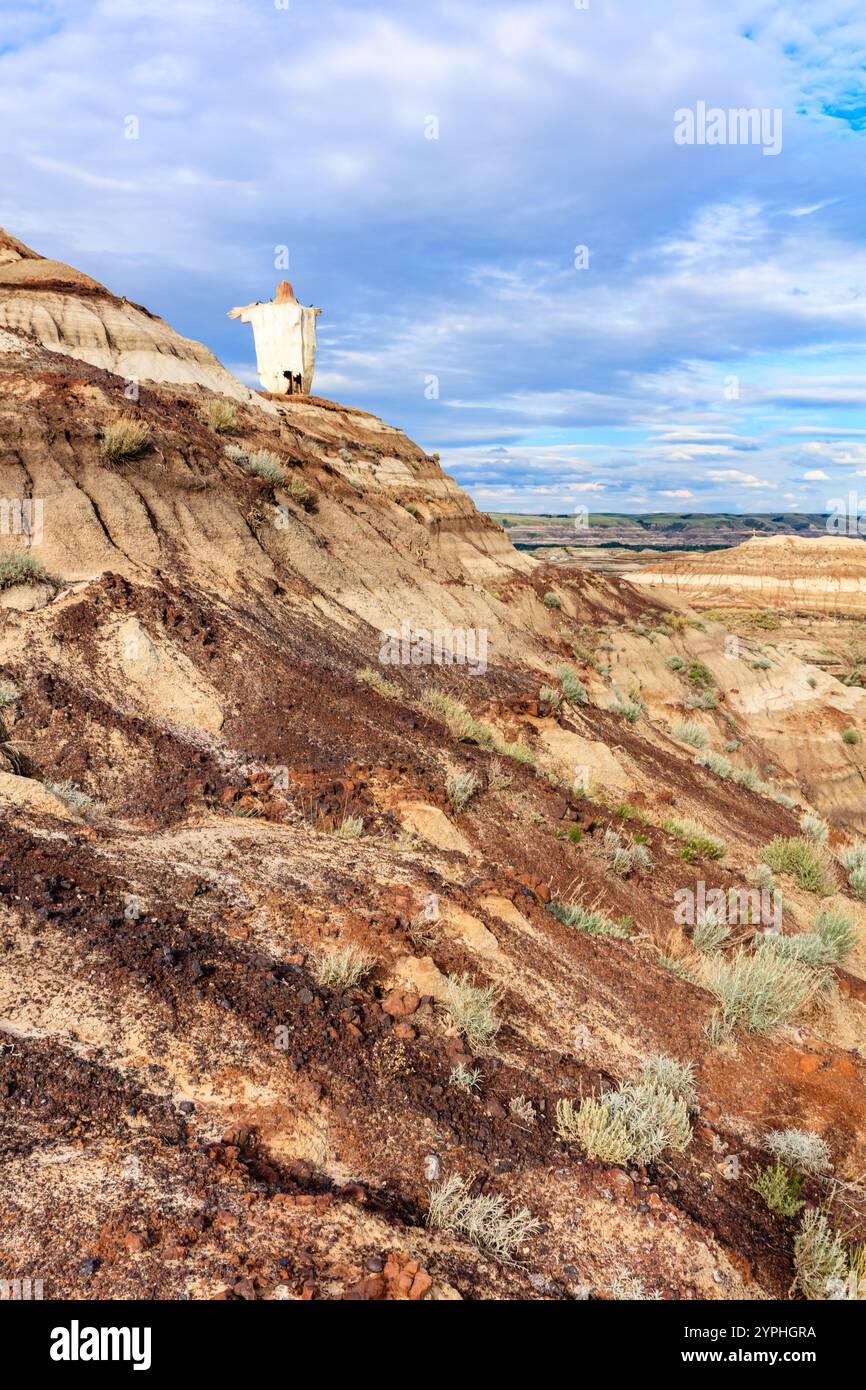 A man stands on a hillside with a statue of Jesus Christ in the ...