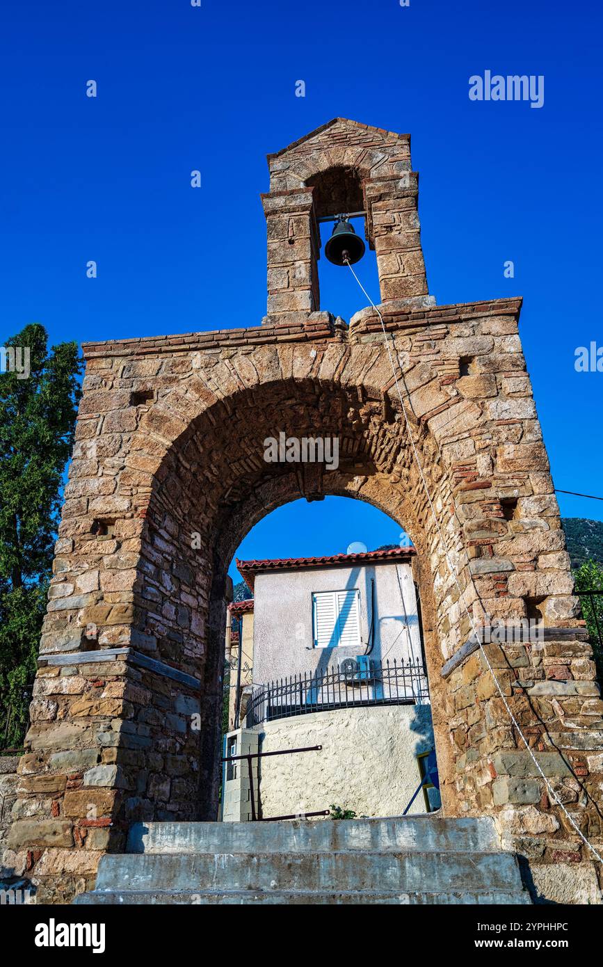 A historic stone bell tower arch in Christianoupolis, Greece, illuminated by sunlight ...