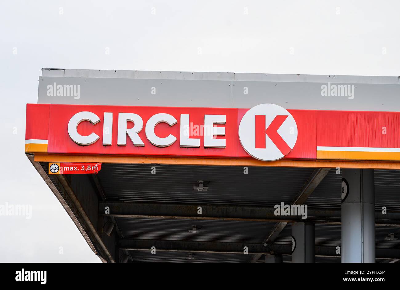 A large, vibrant sign displays the name of a convenience store at a gas ...