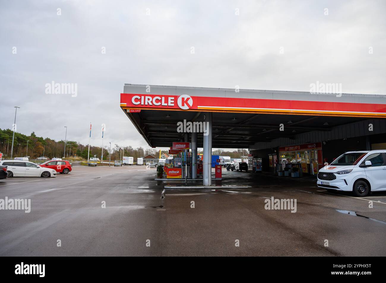 A large, vibrant sign displays the name of a convenience store at a gas ...