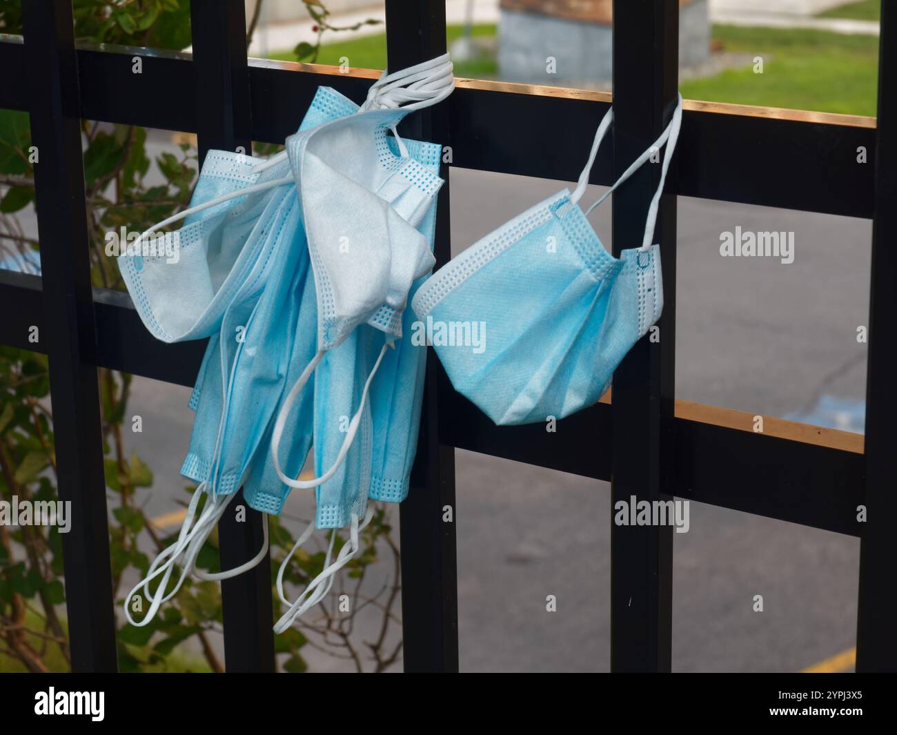 Disposable medical masks hanging on a fence Stock Photo - Alamy
