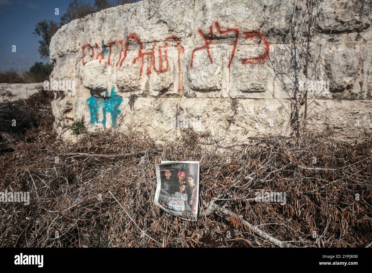A Hebrew slogan is written on a wall on the street of columns and Roman ...