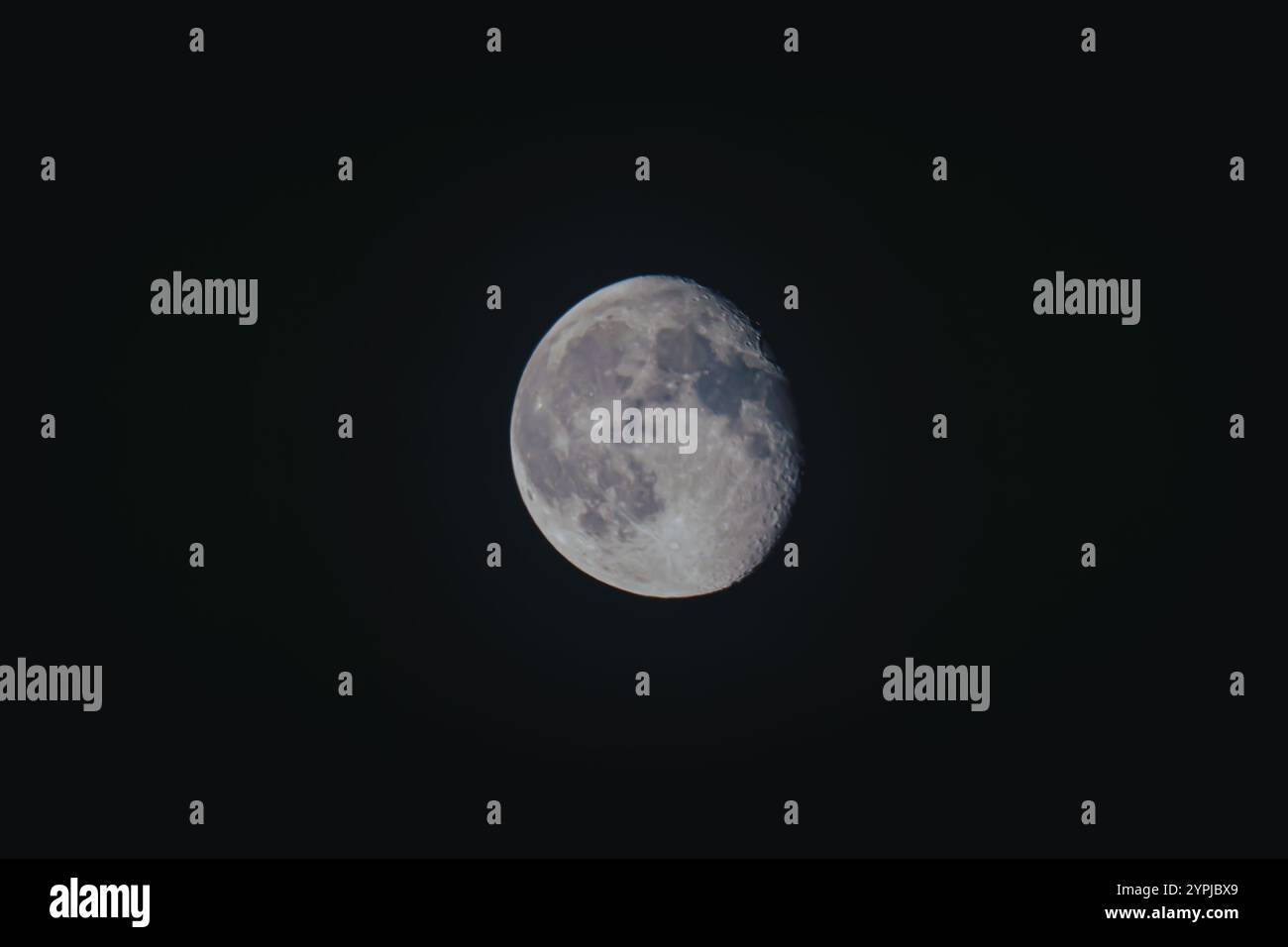 A clear view of the waxing gibbous moon against a dark night sky, showcasing the lunar surface ...