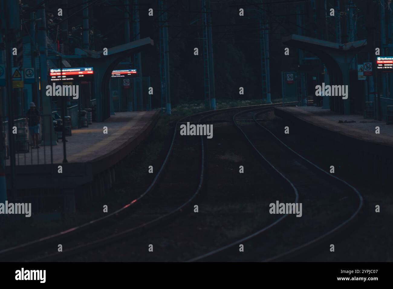 A deserted railway station at dusk with empty platforms and curved ...