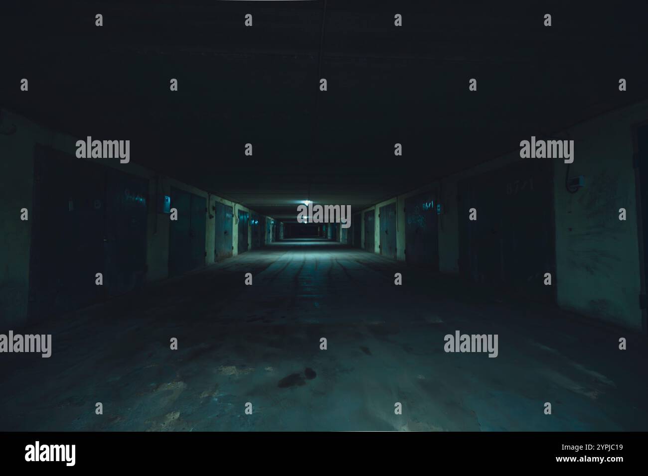 An empty underground parking garage with dim lighting and a desolate ...