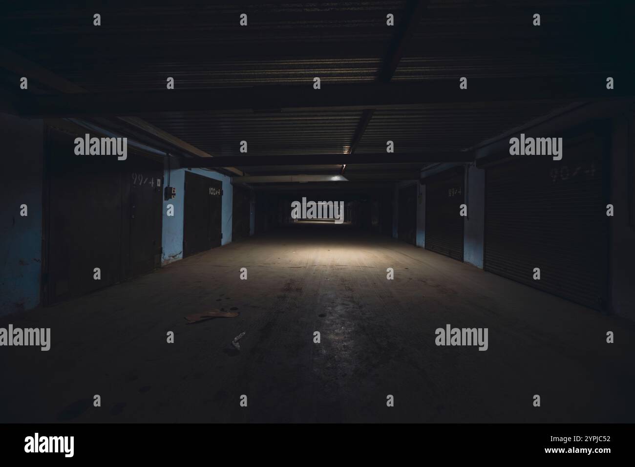 An empty underground parking garage with dim lighting and a desolate ...