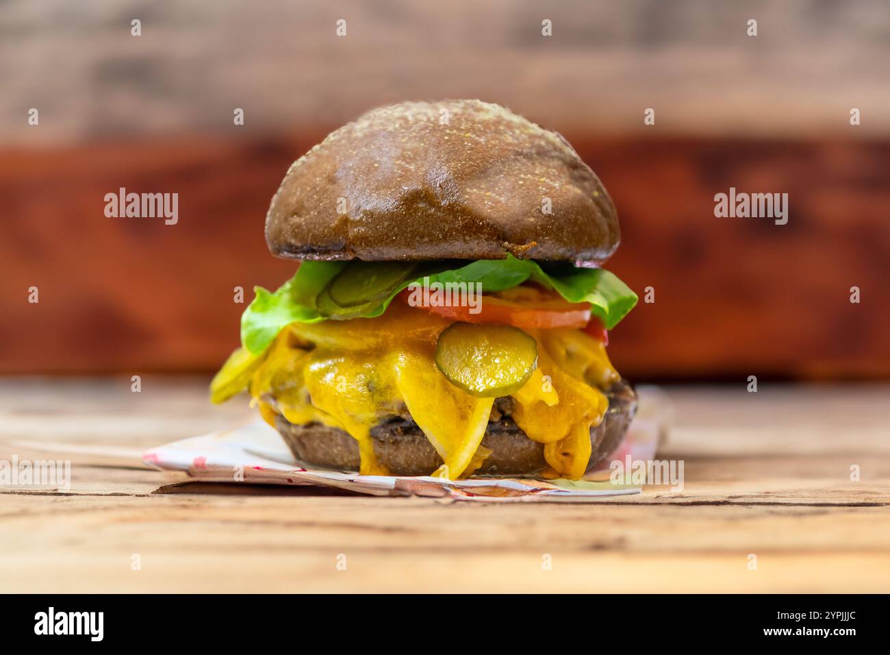 Traditional rustic burger sandwich with cheddar cheese, vegetables and ...