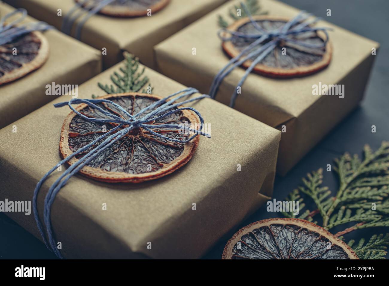Christmas background. Gifts boxes in golden paper with dry oranges and ...