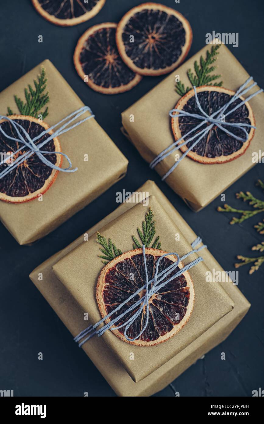 Christmas background. Gifts boxes in golden paper with dry oranges and ...