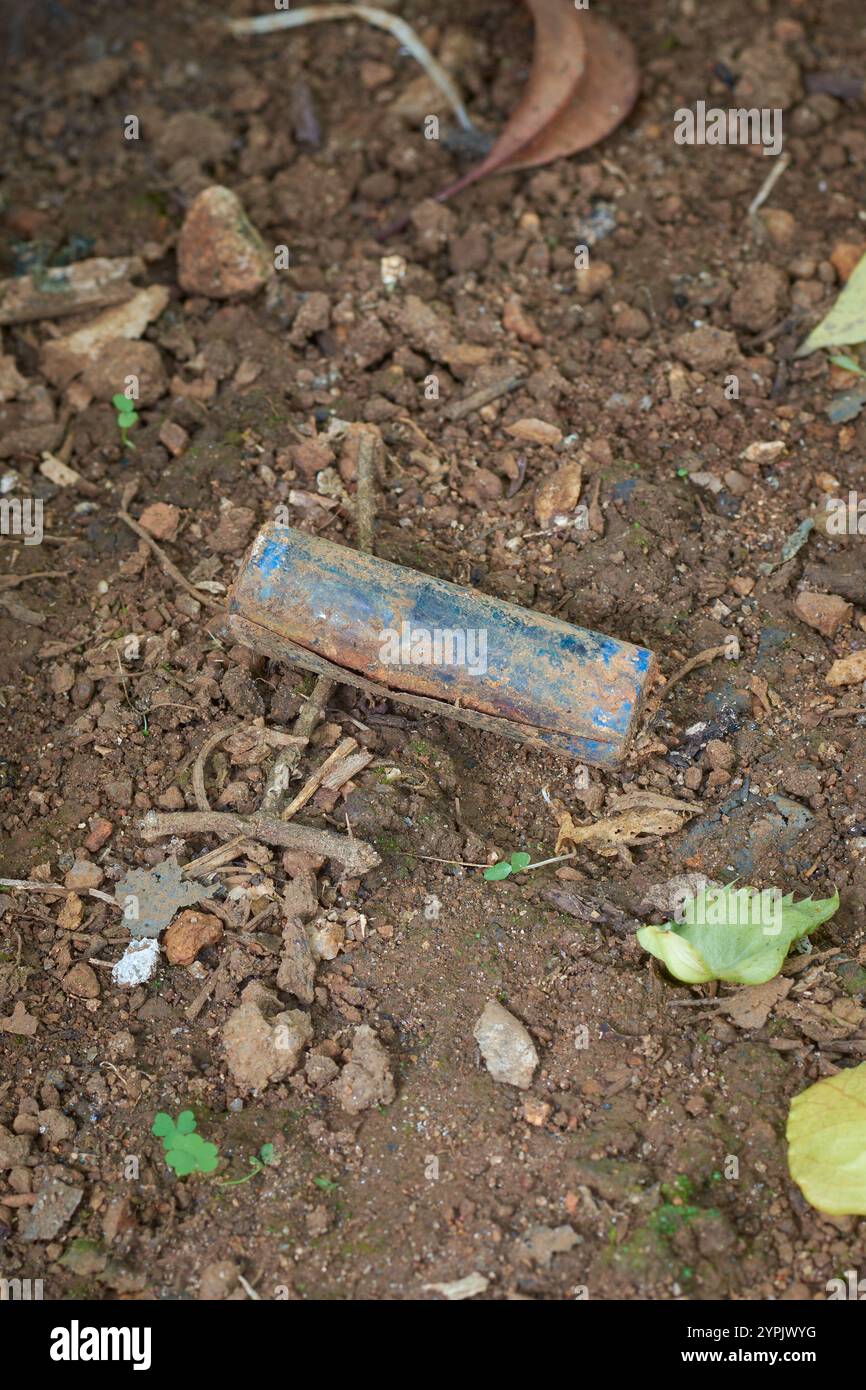 close-up of discarded old corroded battery thrown or lying on ground ...