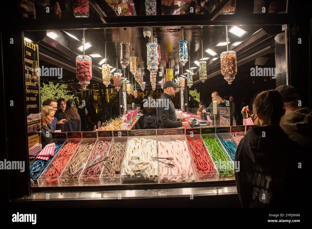 London, UK. 30th Nov, 2024. Shoppers choose and buy sweets outside the ...