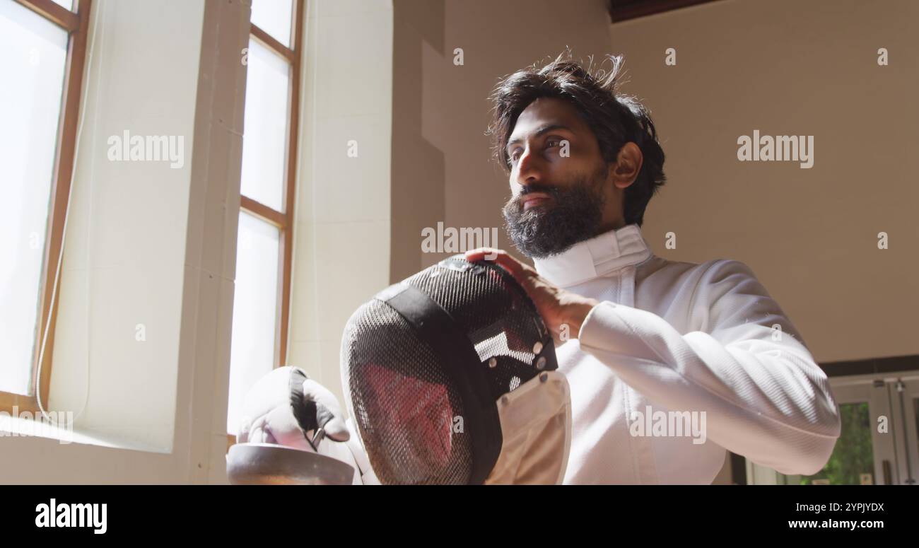 Low angle side view of a confident focused biracial male fencer athlete ...