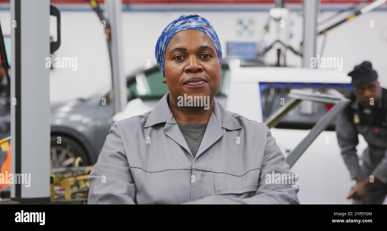 Portrait of an African American female car mechanic working in a ...