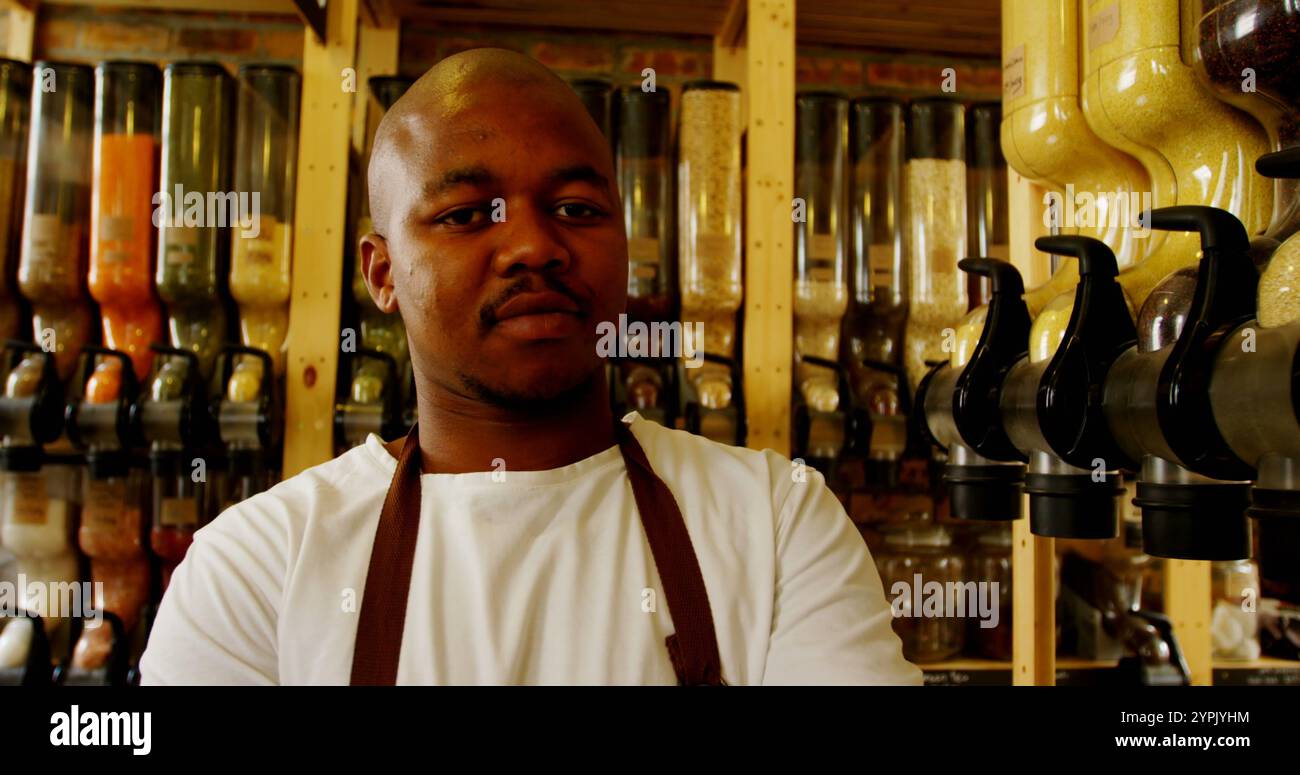 Male staff standing with arms crossed in supermarket Stock Photo - Alamy