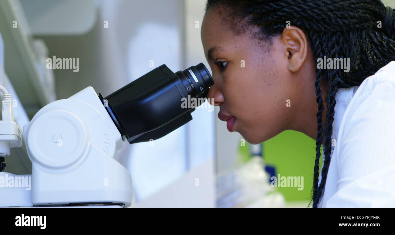 Scientist looking through microscope in laboratory Stock Photo - Alamy