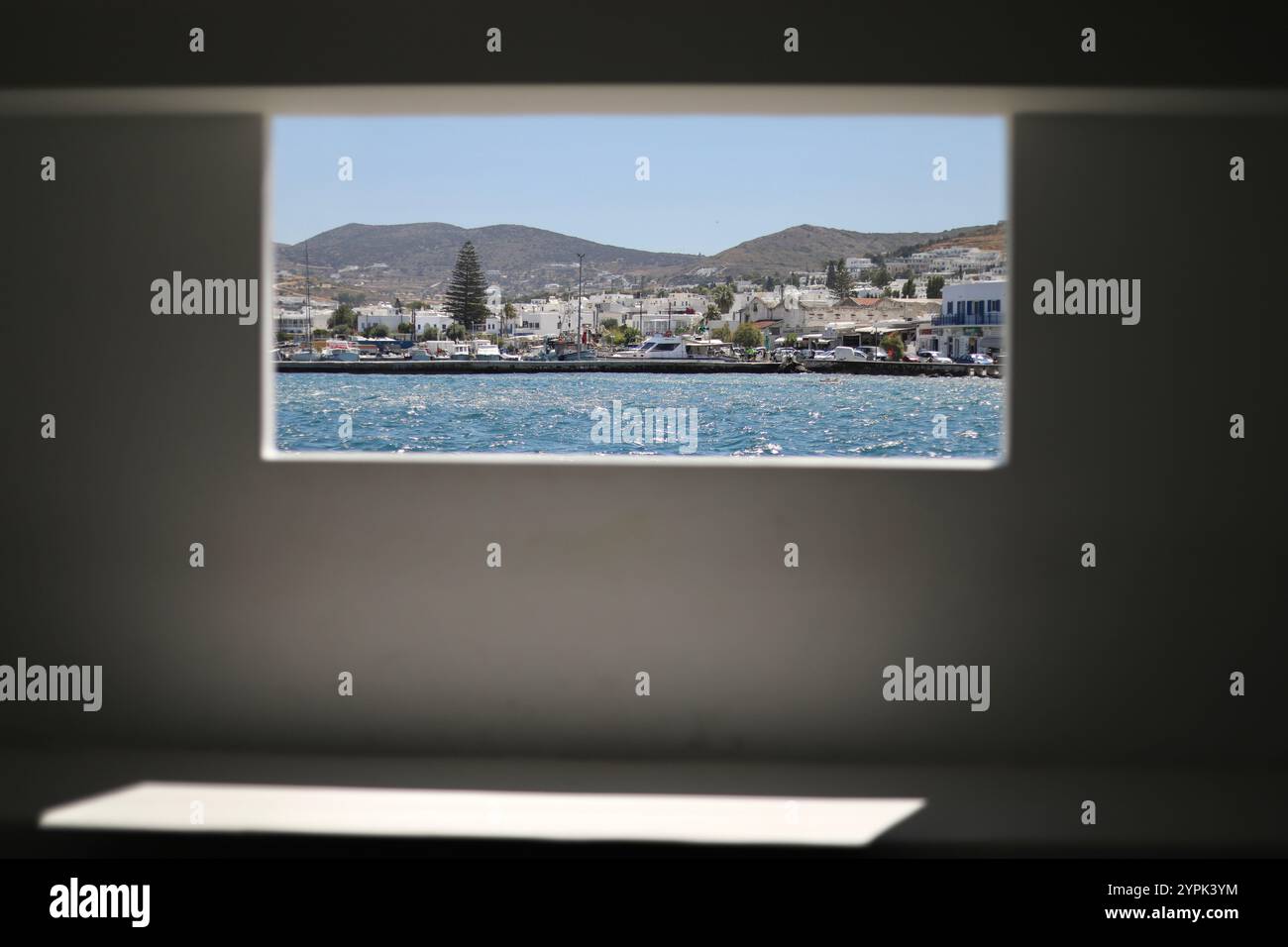 The port of Parikiá and the Aegean Sea are seen from a window in the ...