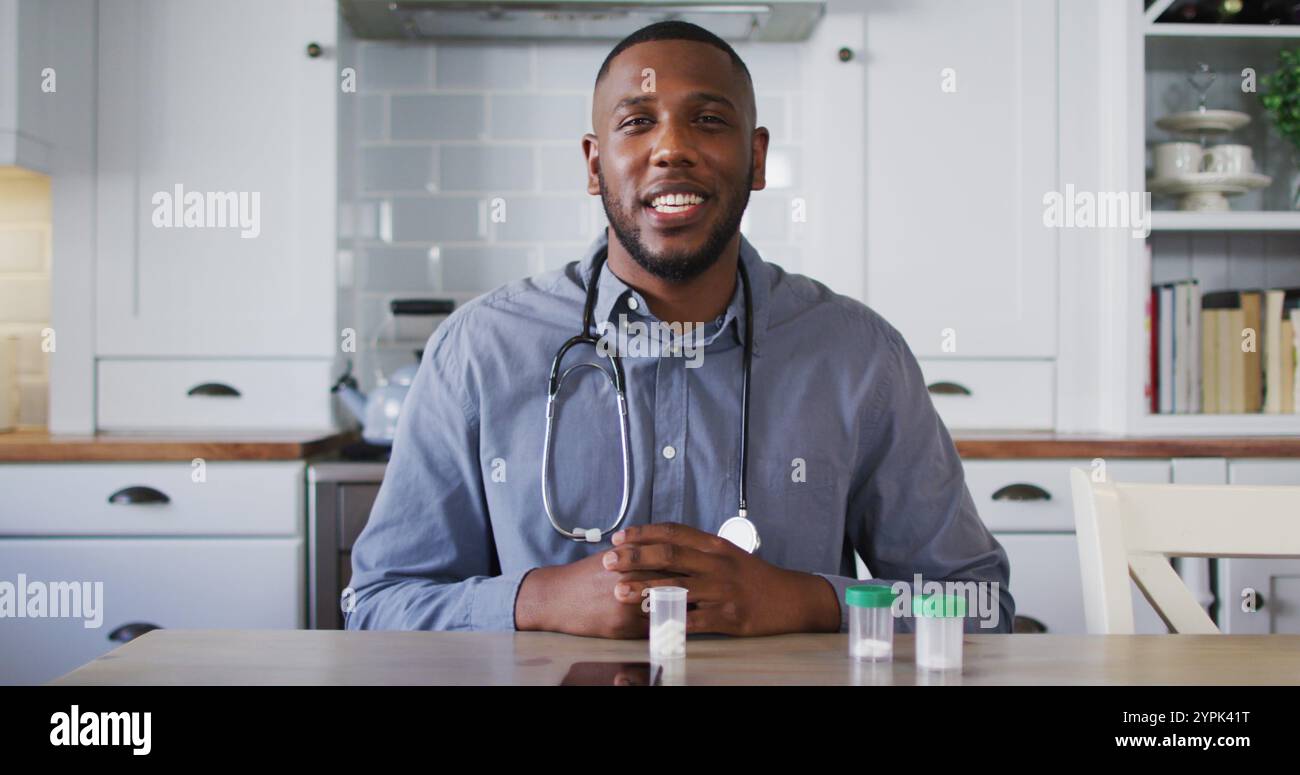 Portrait of african american doctor holding medication container ...