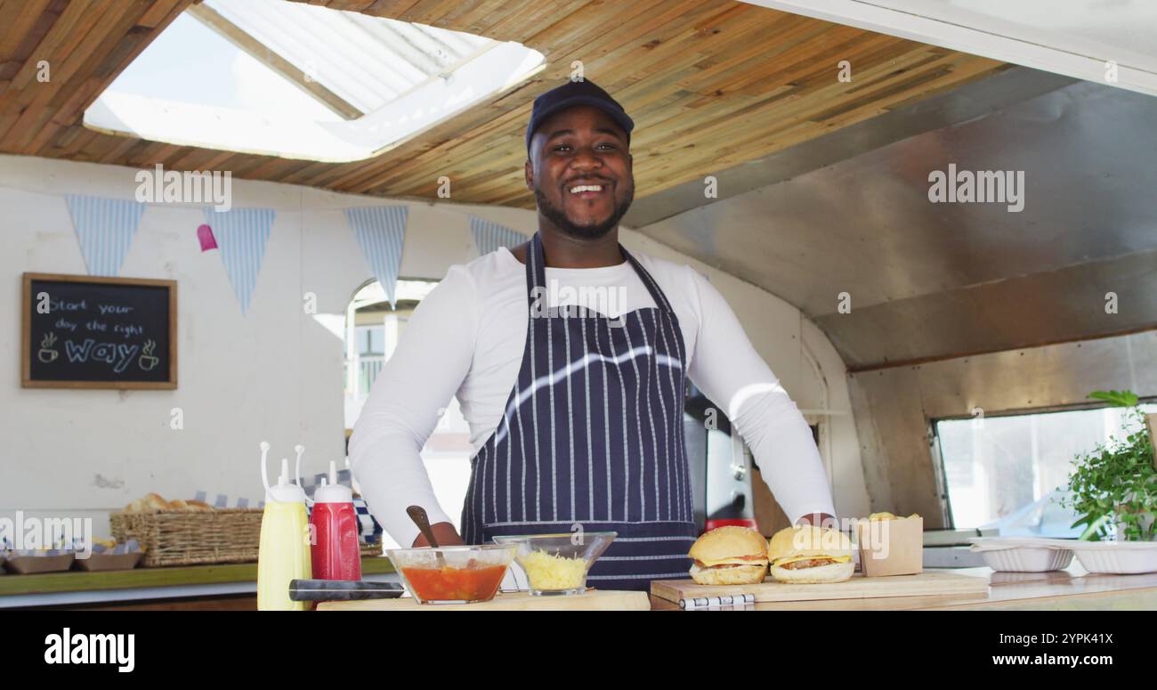 Portrait of african american man wearing apron smiling while preparing ...