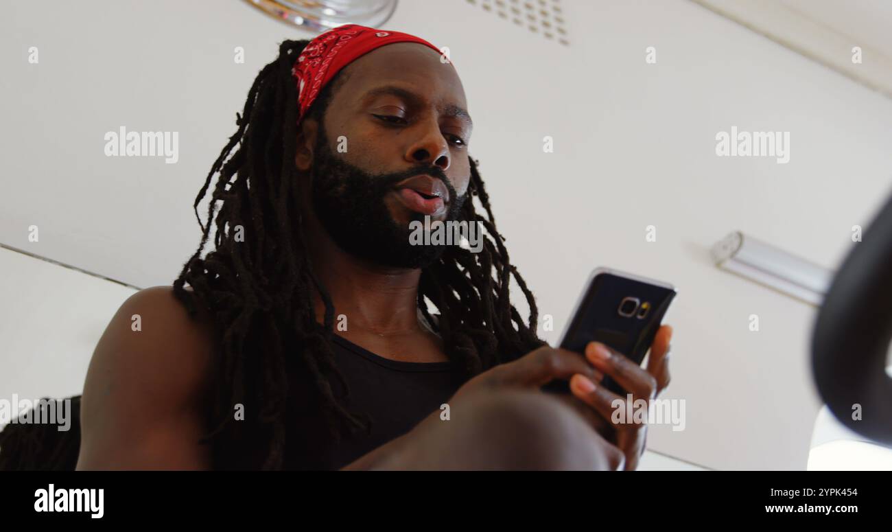 Male boxer using mobile phone while exercising in fitness studio Stock ...