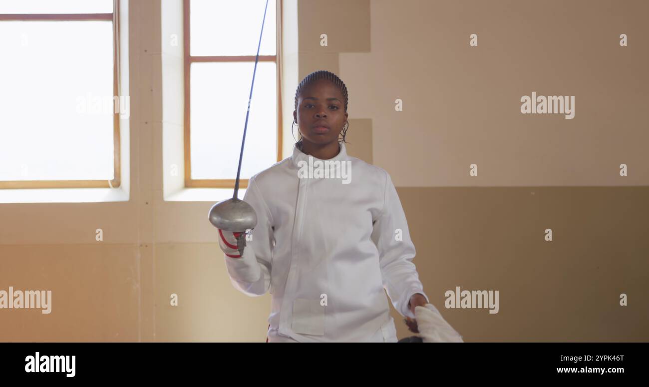 Portrait of a focused biracial female fencer athlete during a fencing ...