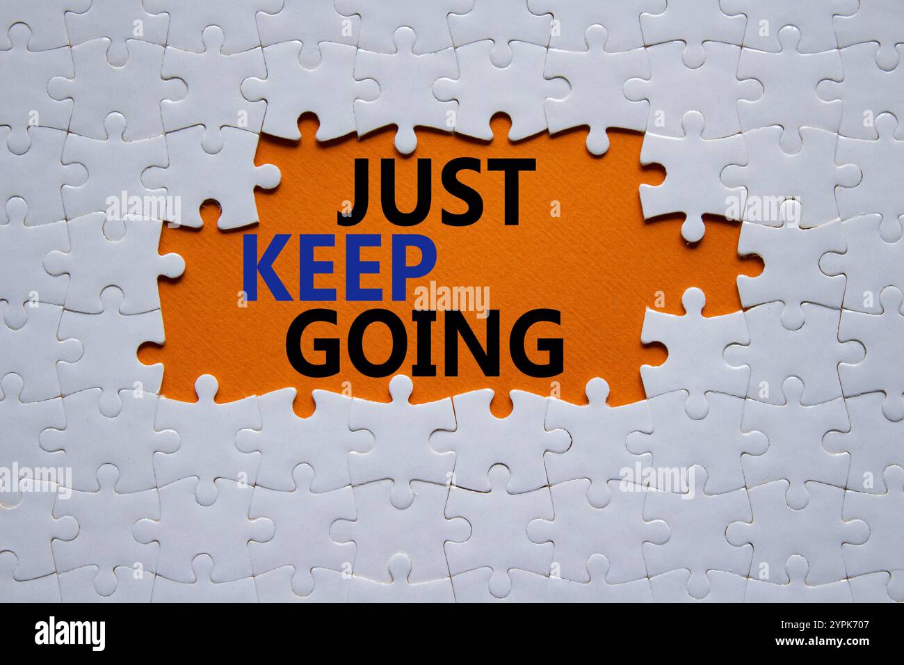 Just keep going symbol. White puzzle with words Just keep going. Beautiful orange background ...