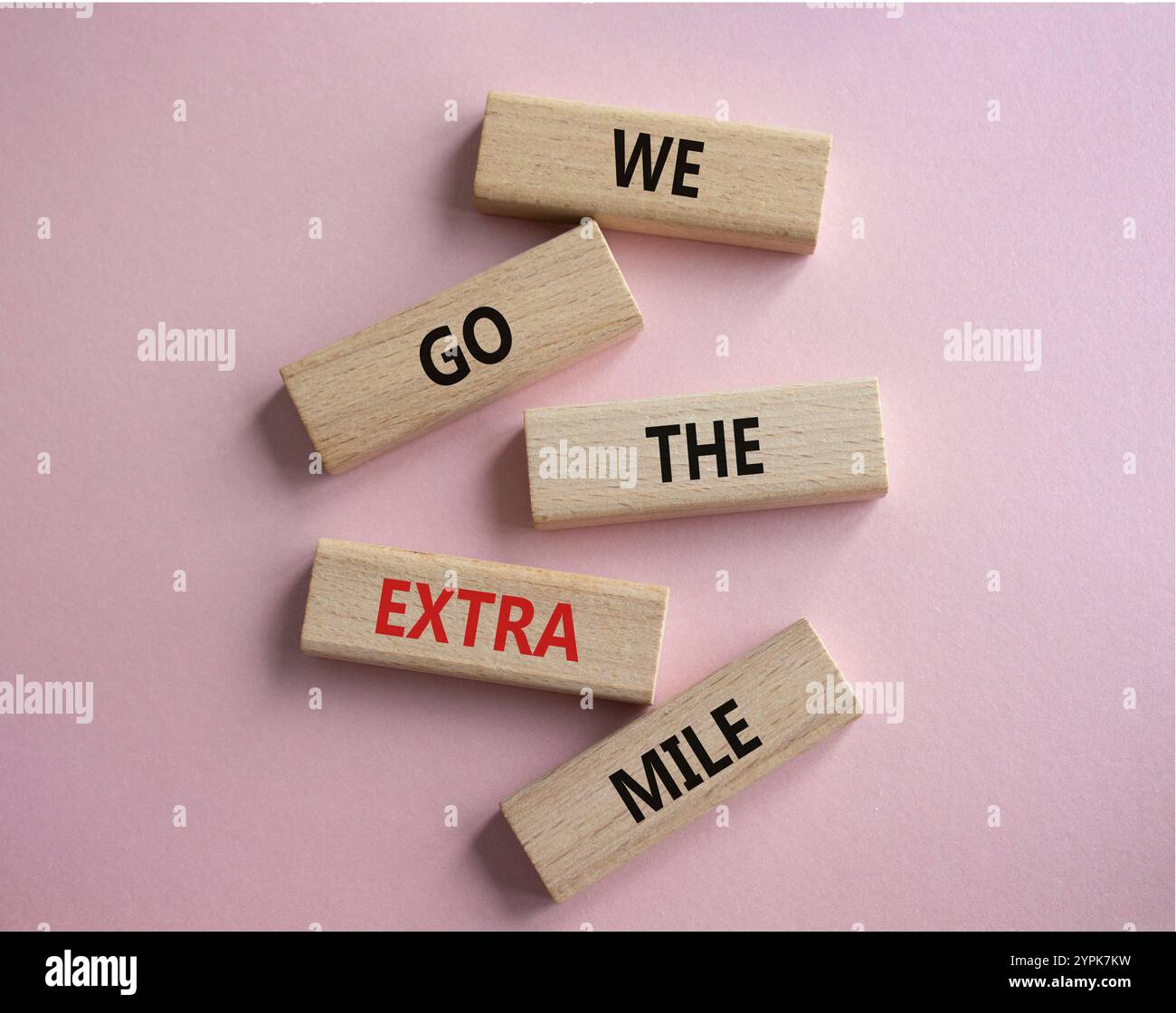 We go the extra mile symbol. Wooden blocks with words We go the extra ...