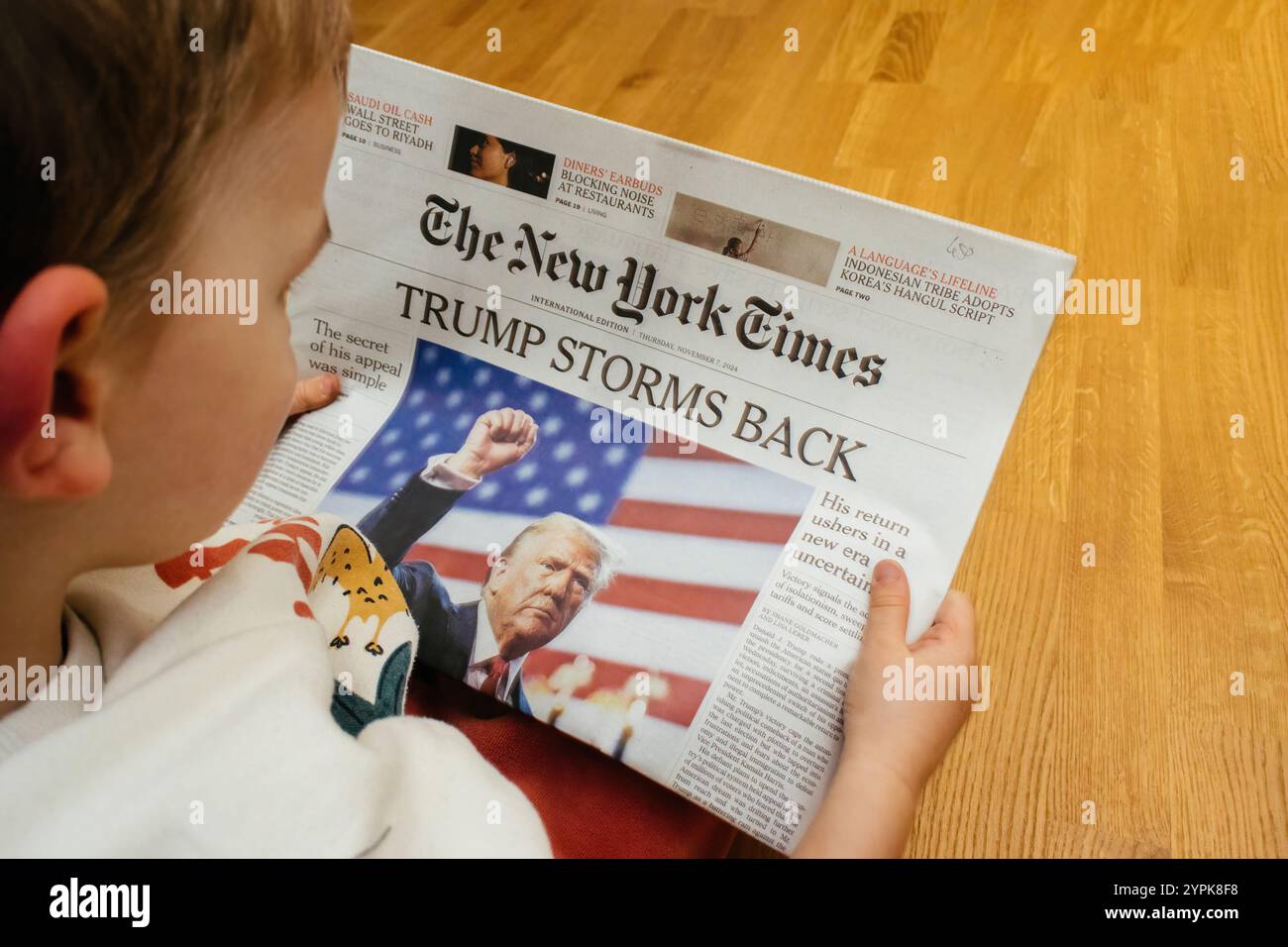 Paris, France - Nov 13, 2024: A child reads the international edition ...