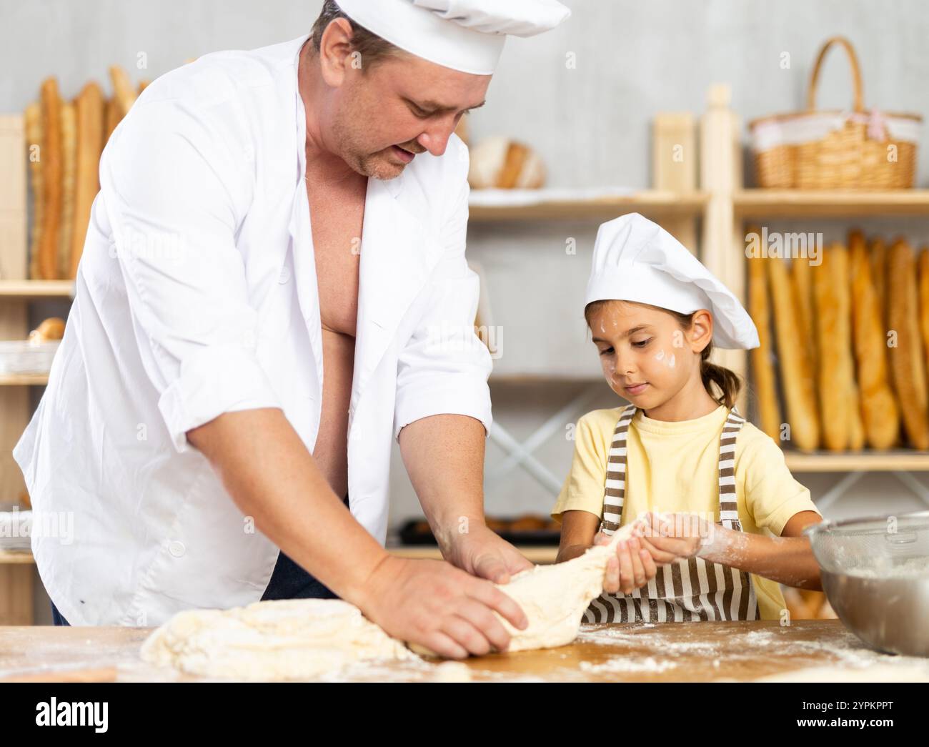Bakers dad teaches his daughter niece to knead dough Stock Photo - Alamy