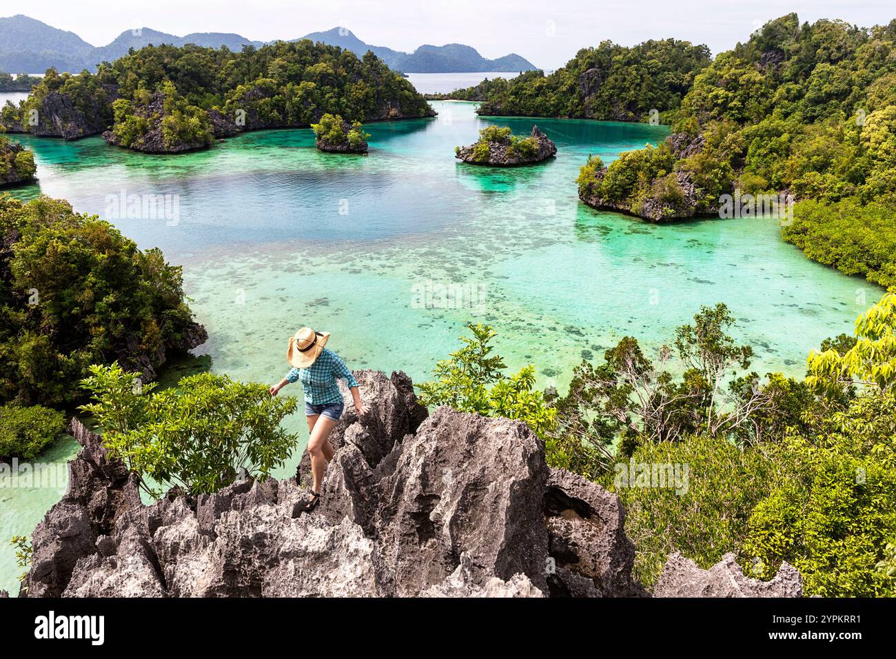 Woman tourist on a rocky hill at the spectacular idyllic lagoon ...