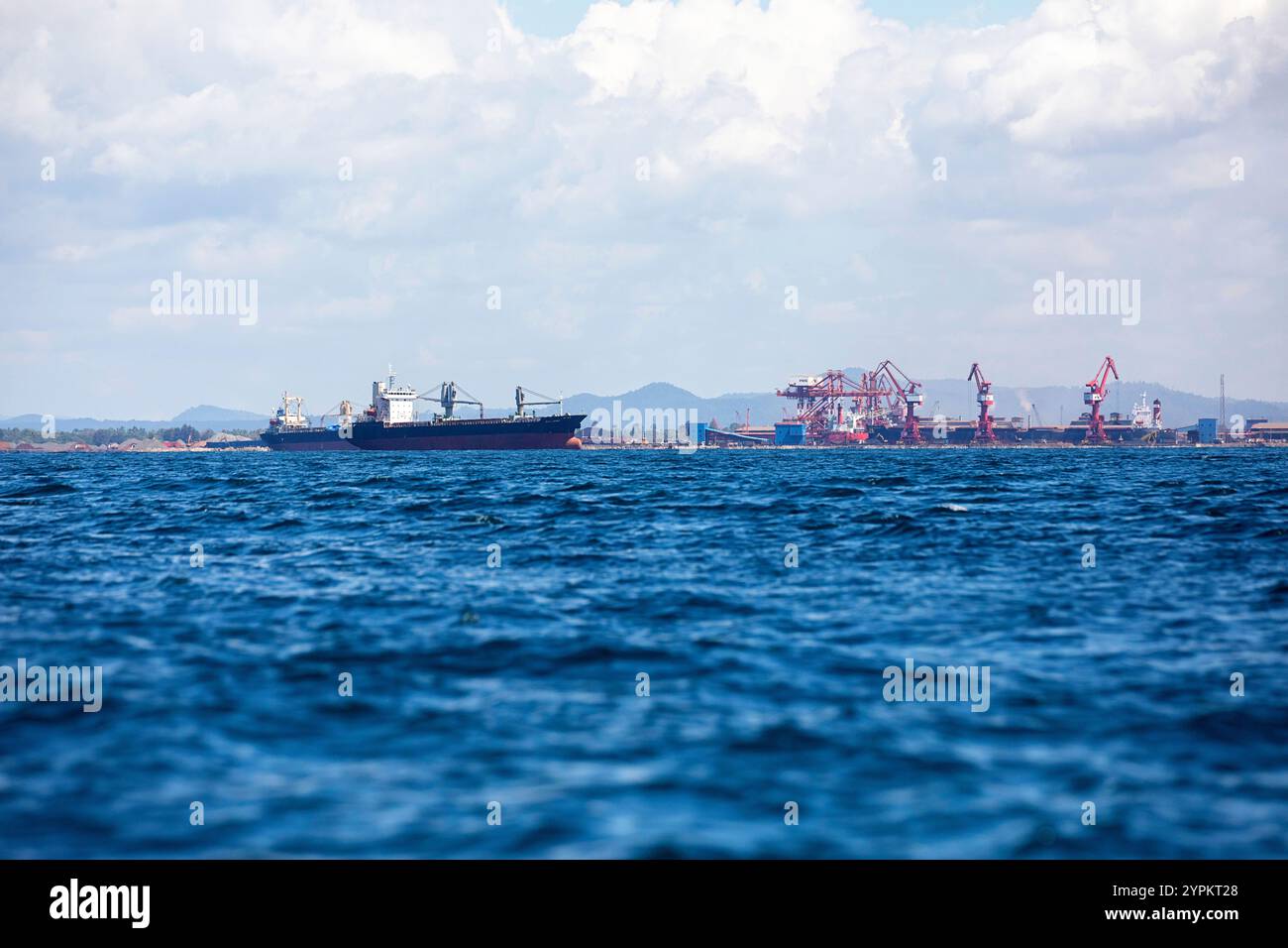 Cargo ships close to nickel open pit mines and factories of nickel companies, waiting for ...