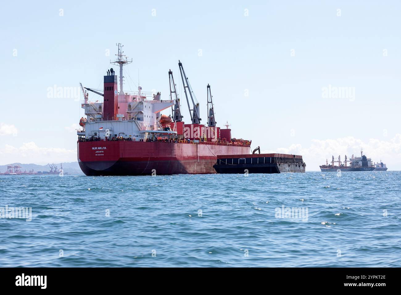 Cargo ships close to nickel open pit mines and factories of nickel companies, waiting for ...