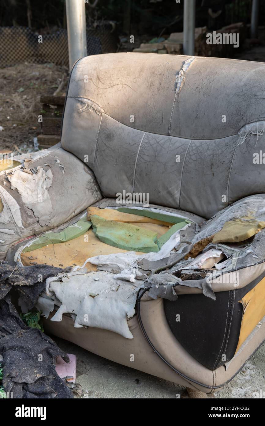 a badly damaged sofa on the roadside at vertical composition Stock ...