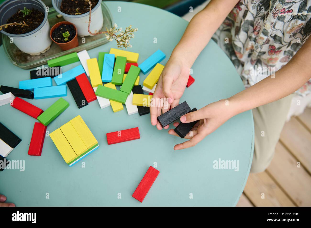 A child is engaged in a playful activity, building with colorful wooden ...
