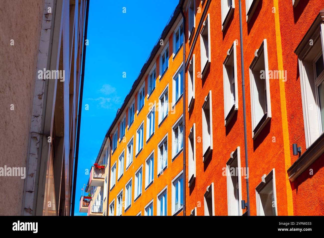 Narrow alleyway between two buildings. Building on the right is painted ...